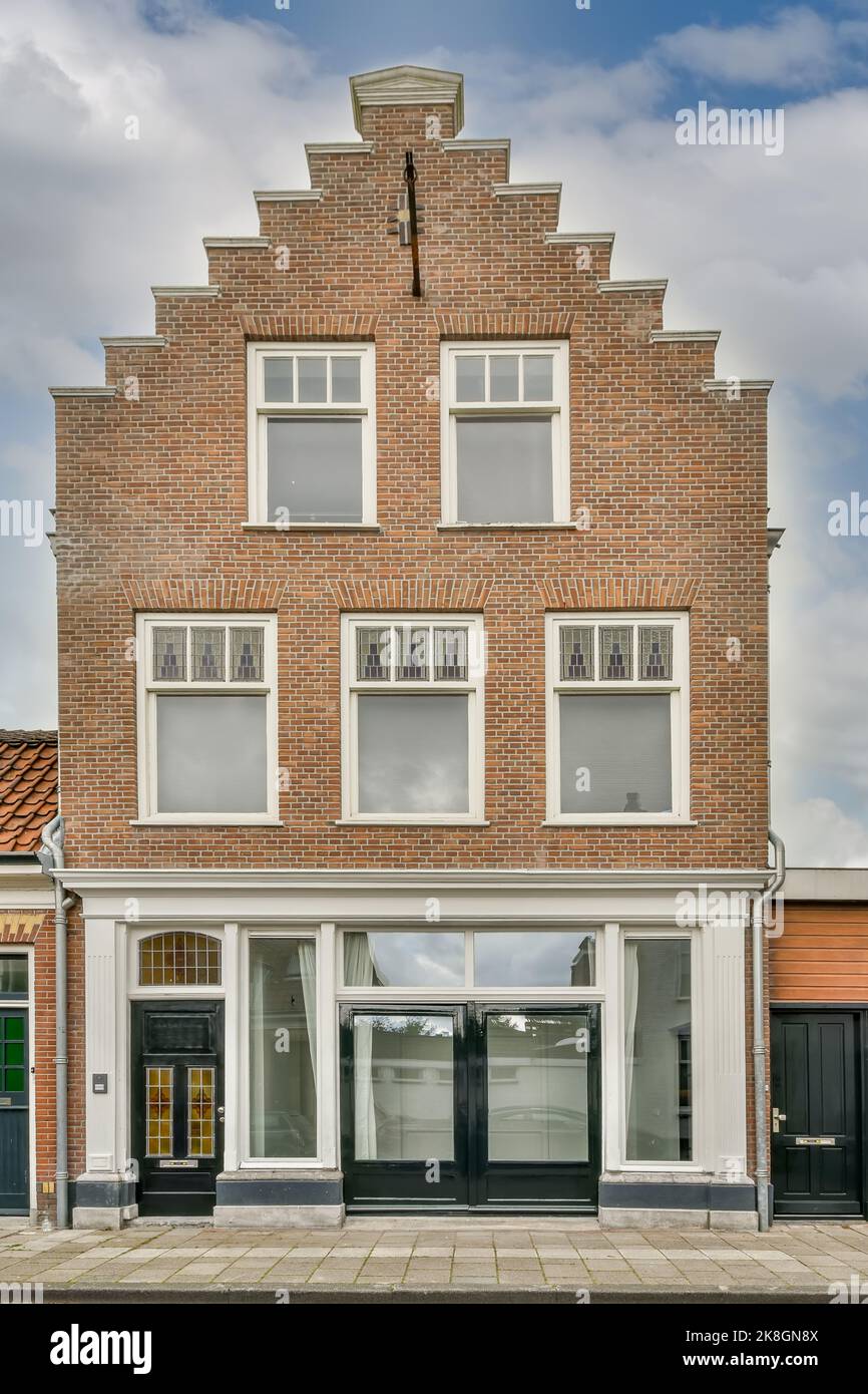 View of a street with houses lined up under a blue sky with clouds ...