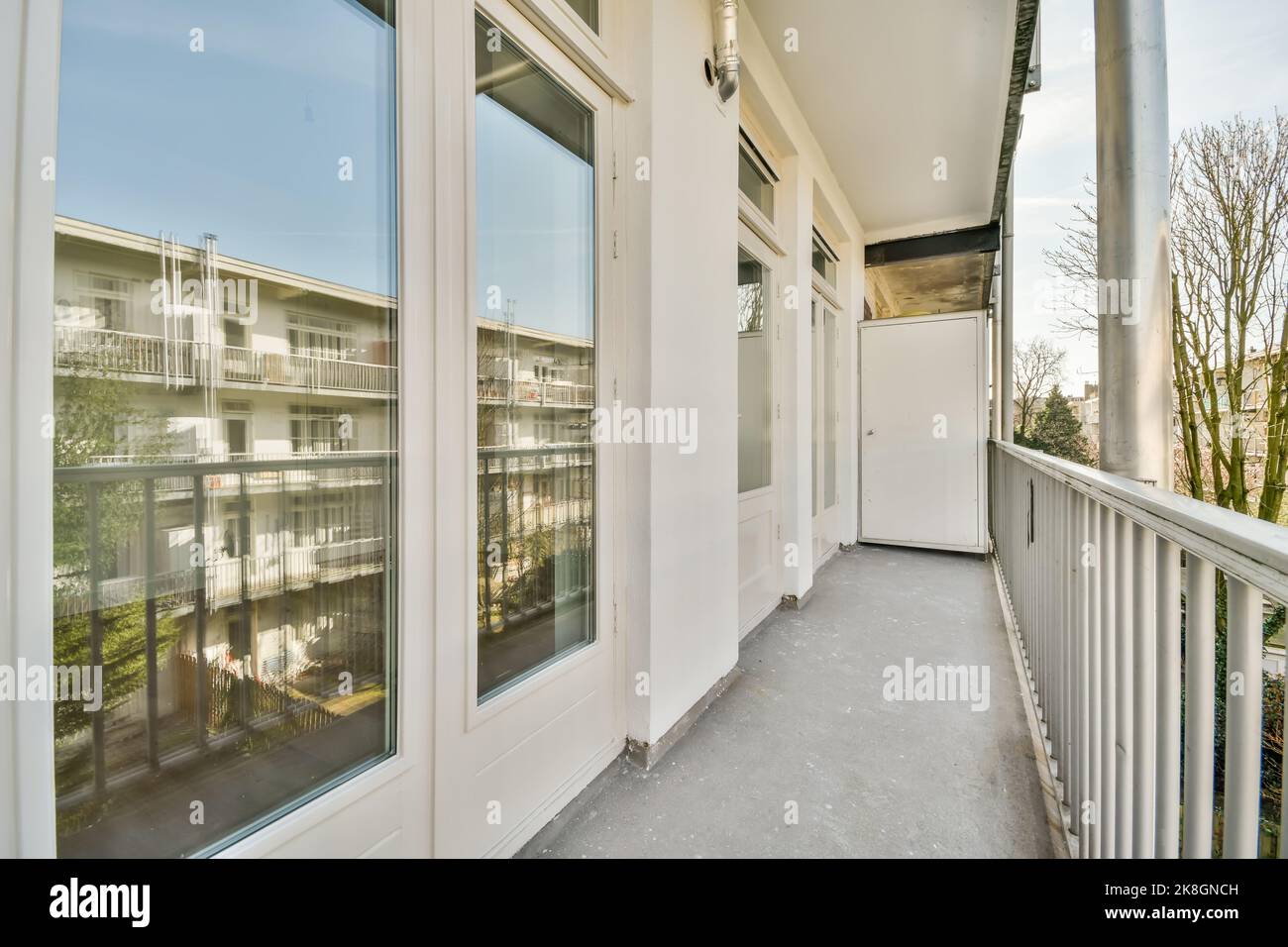 Balcony of residential building with glass doors with reflection and ...
