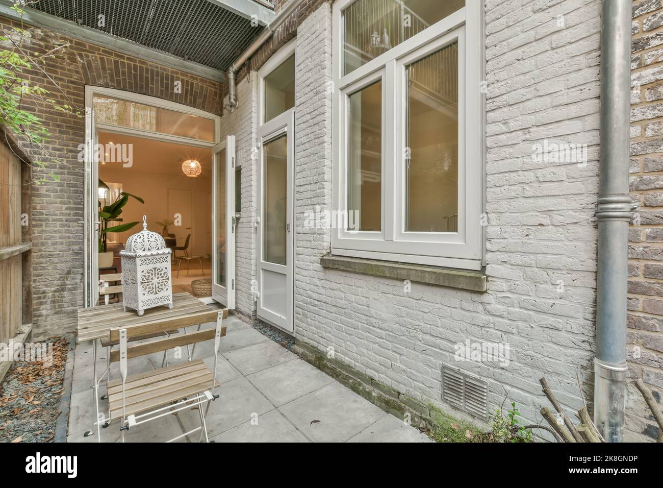 Backyard of a house with table and chairs next to a door Stock Photo ...