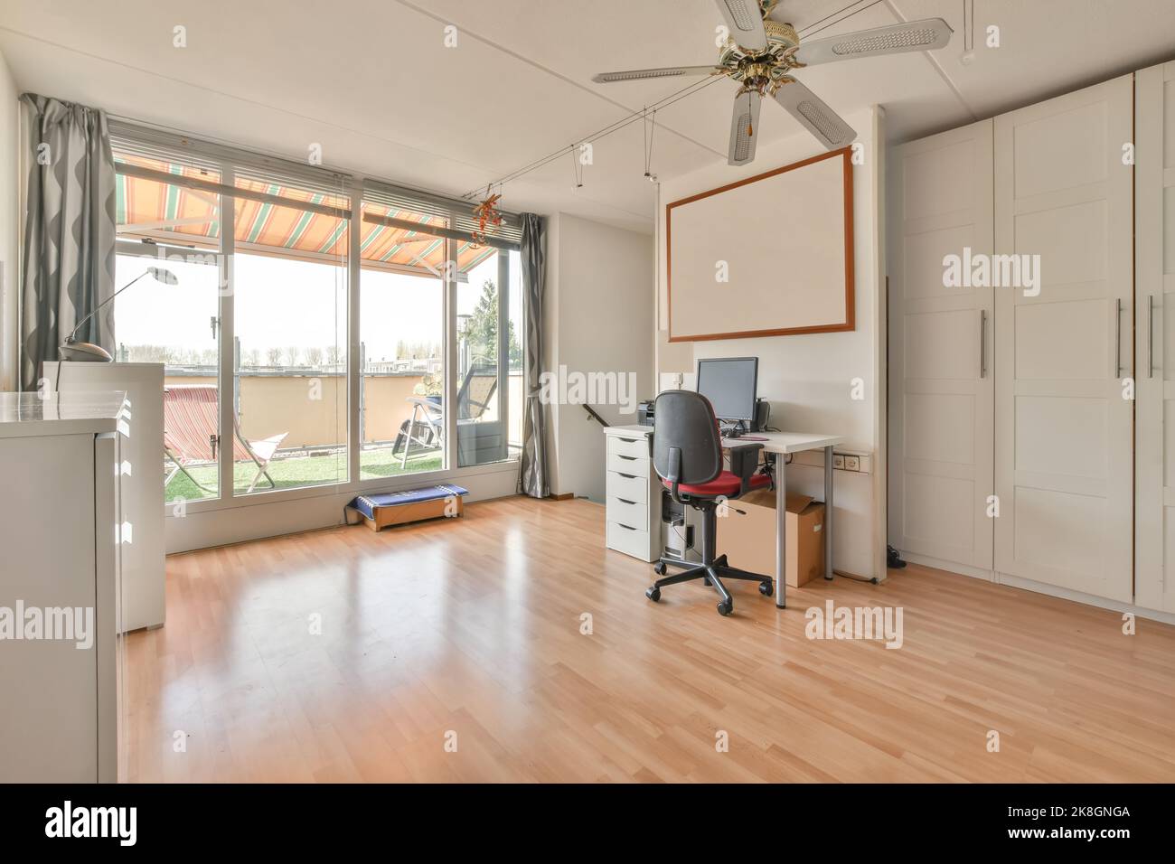 Side view of room with a desk by a bright window Stock Photo - Alamy