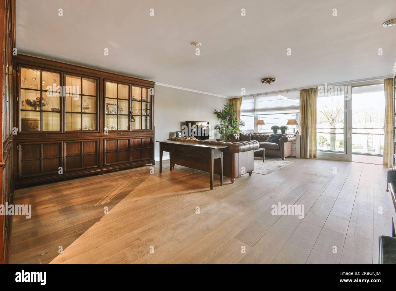 Wooden classic cupboard placed at wall in light living room with sofa ...
