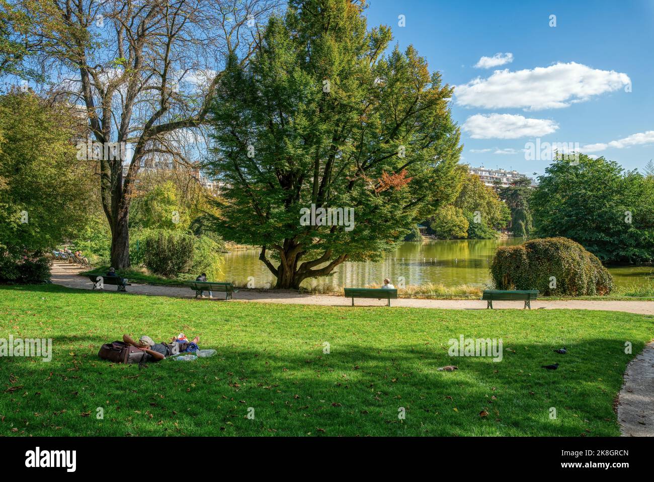 Parisians sunbathing on the shore of the lake of Parc Montsouris ...