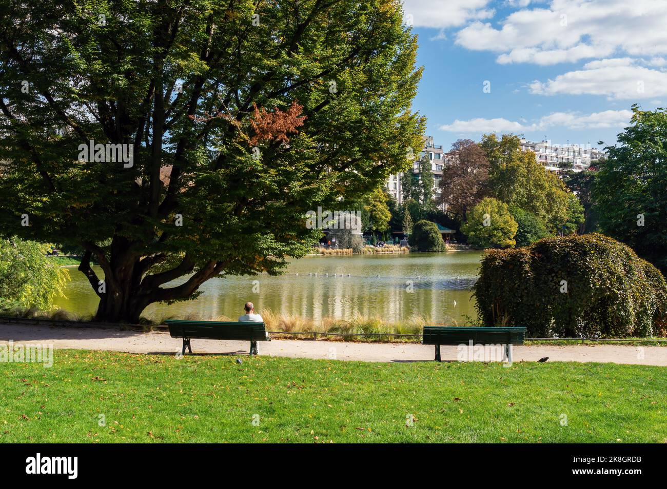 Parisians sunbathing on the shore of the lake of Parc Montsouris ...