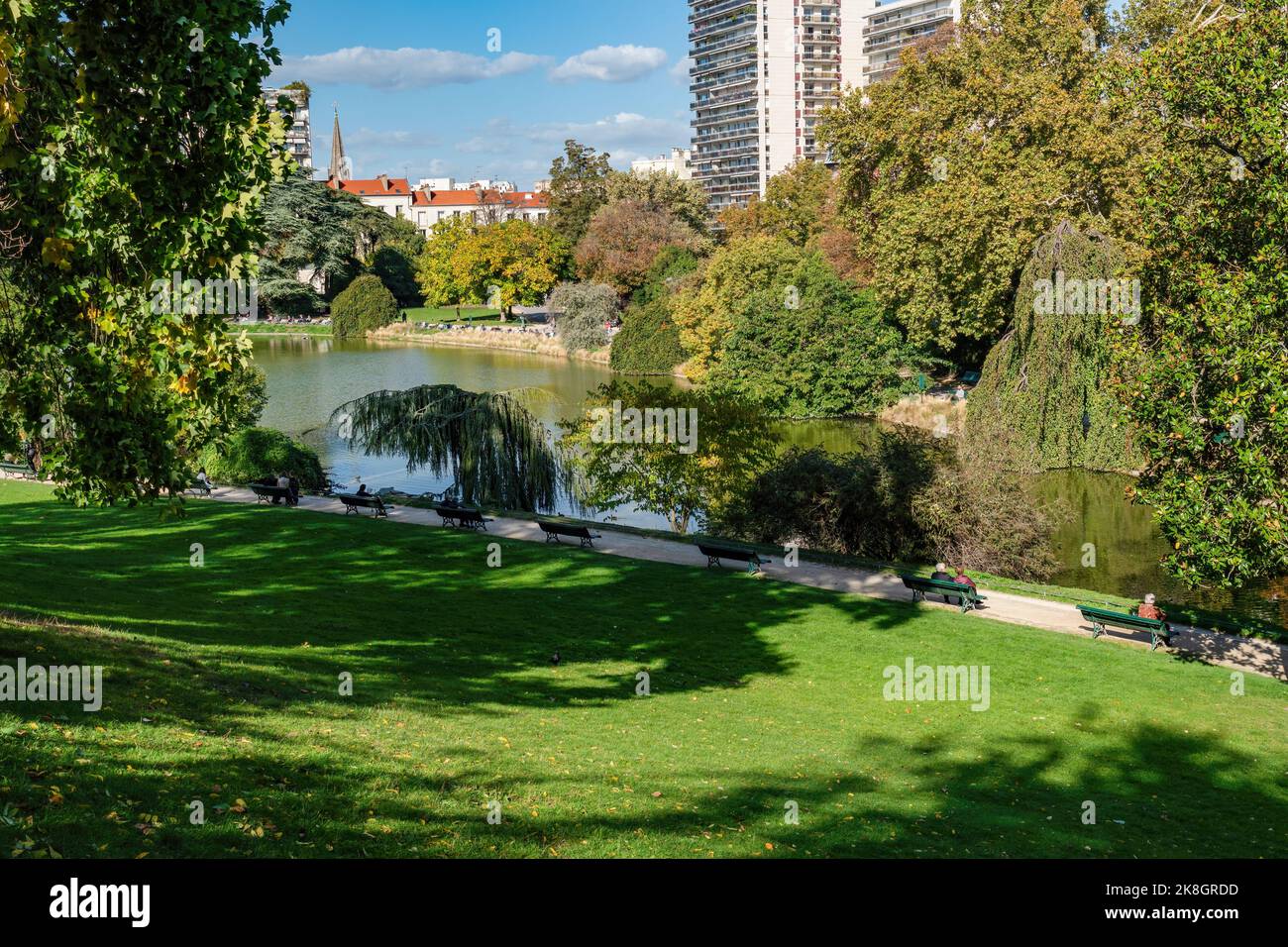 Parisians sunbathing on the shore of the lake of Parc Montsouris ...