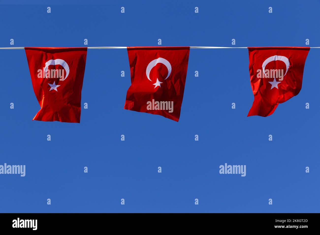Many red Turkish flags isolated at sunny blue sky background ...