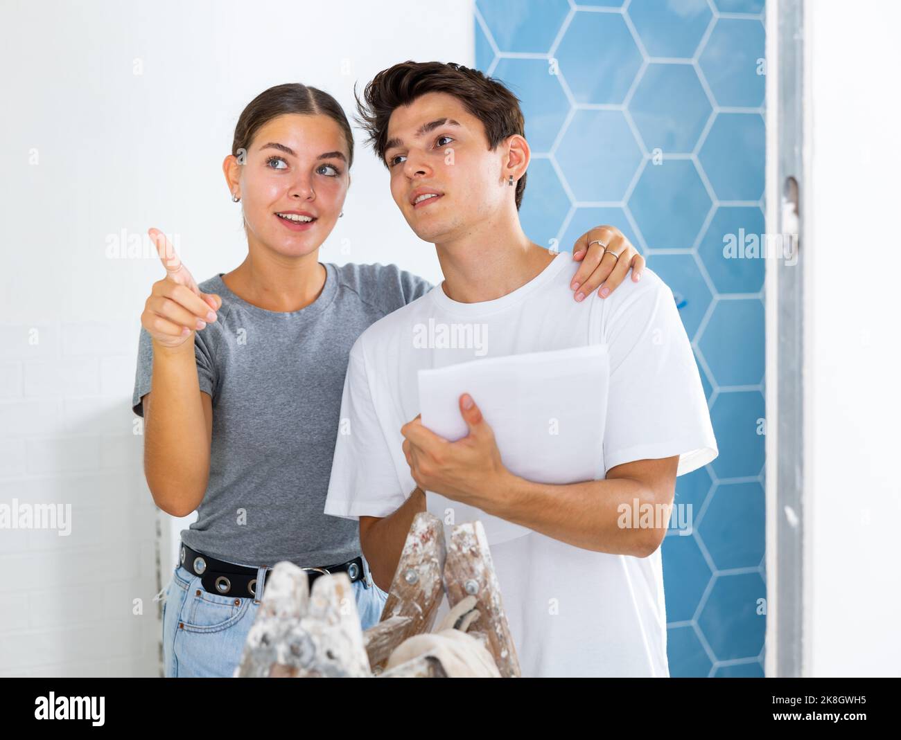 Young couple with documents checks the number of tiles, making ...