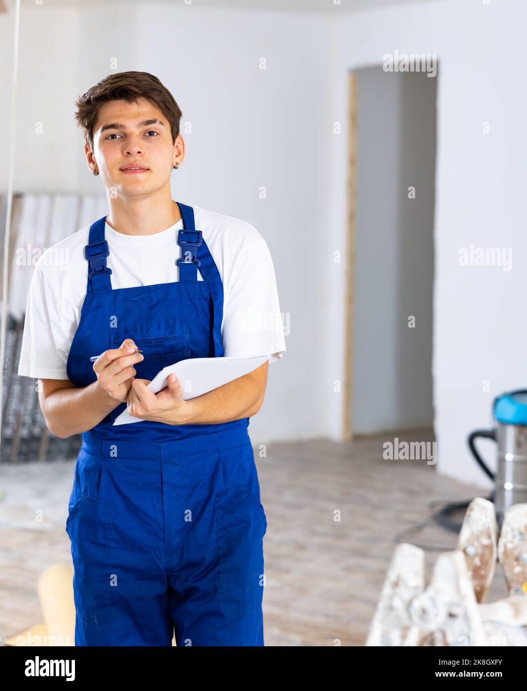 Focused contractor taking notes while planning renovation works in ...