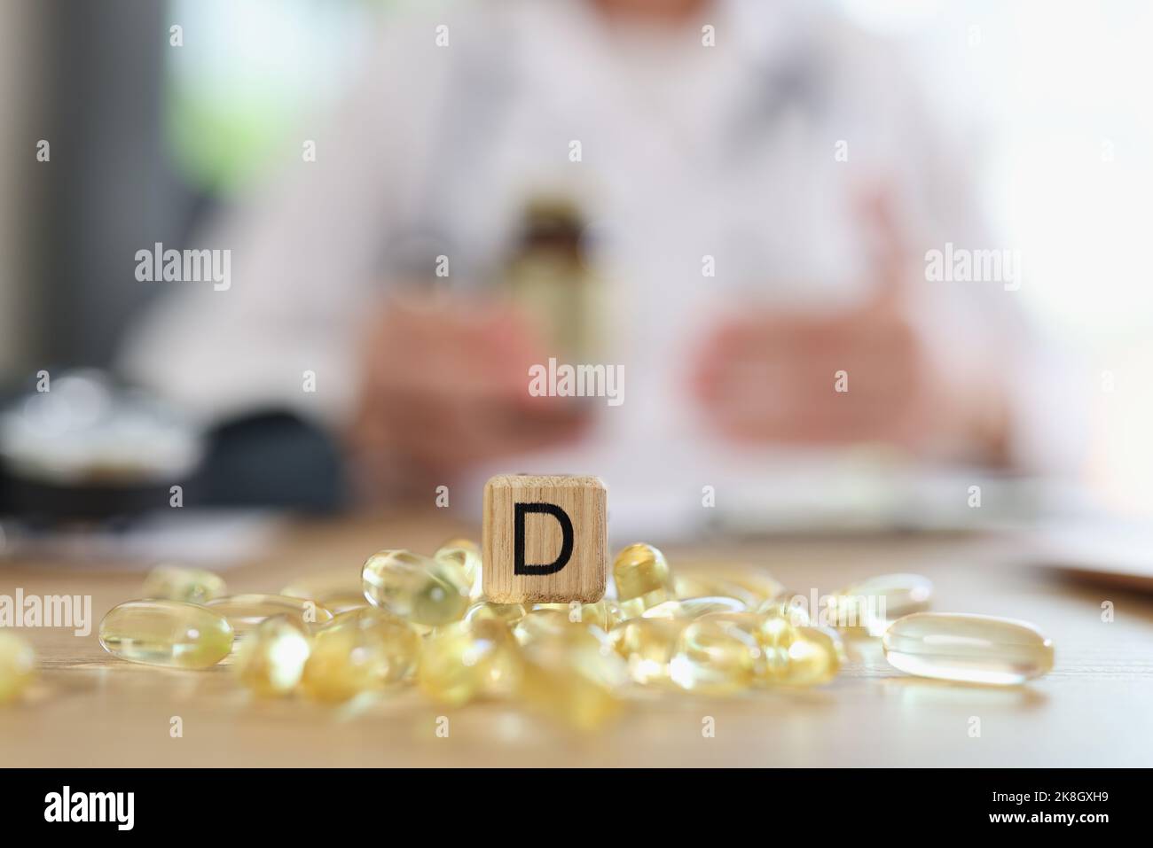 Transparent yellow capsules and wooden cube with letter d Stock Photo ...