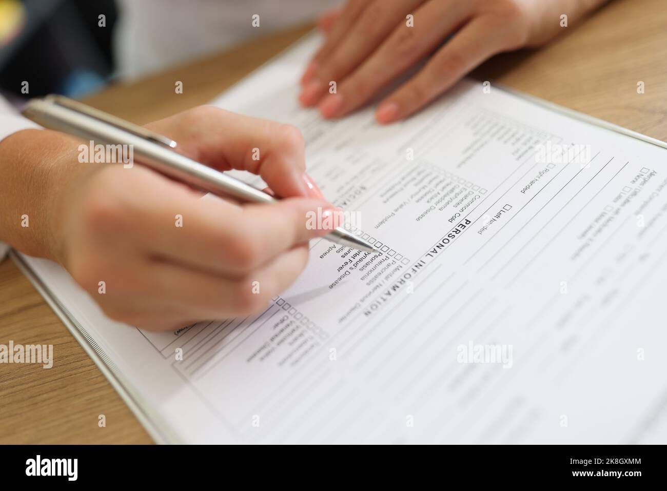 Woman patient filling medical form in clinic Stock Photo - Alamy