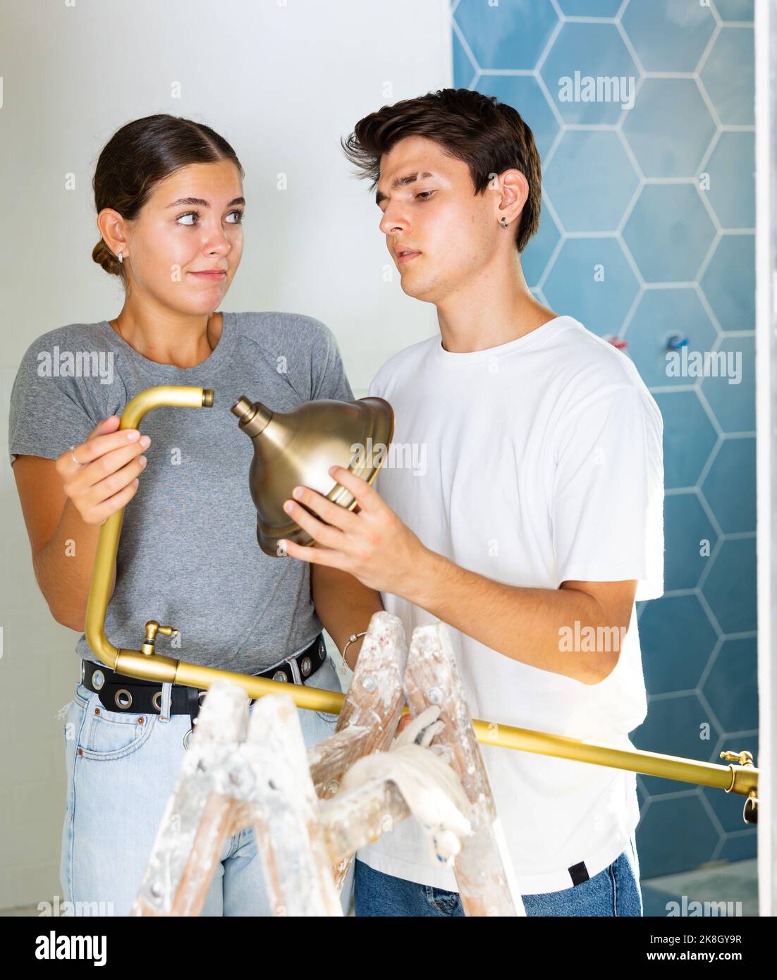 Young couple preparing shower to installation in house under renovation ...