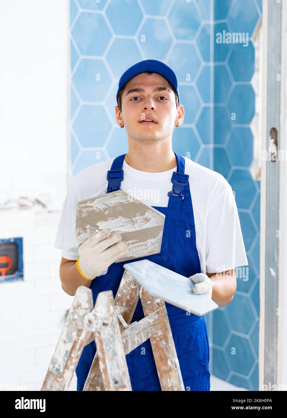 Young guy laying tiles hi-res stock photography and images - Alamy