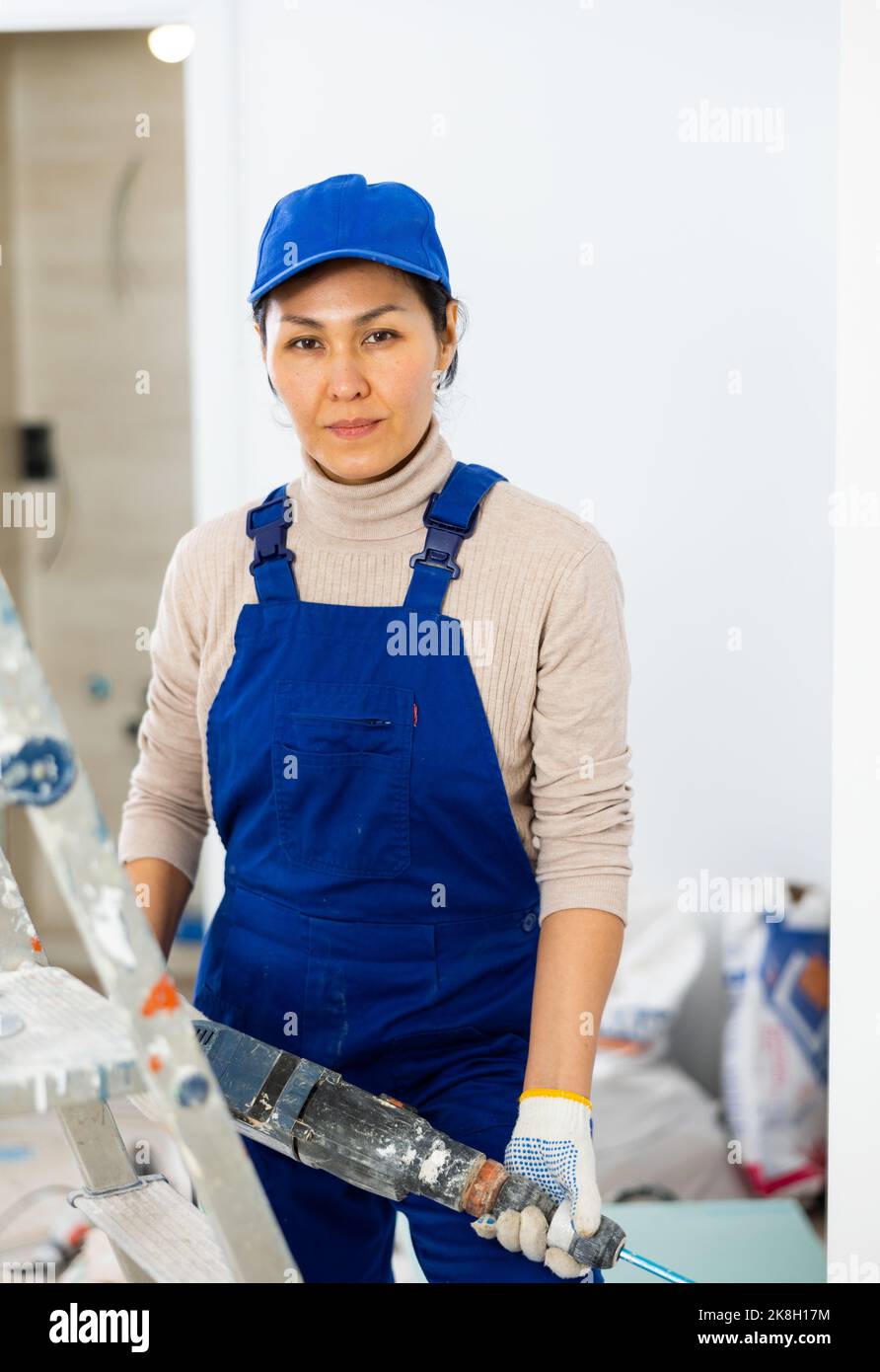 Portrait of female builder with paint mixing machine Stock Photo - Alamy