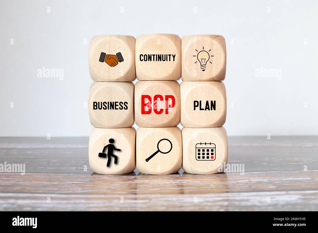 BUSINESS CONTINUITY PLAN, text on wooden block on a gray BACKGROUND ...