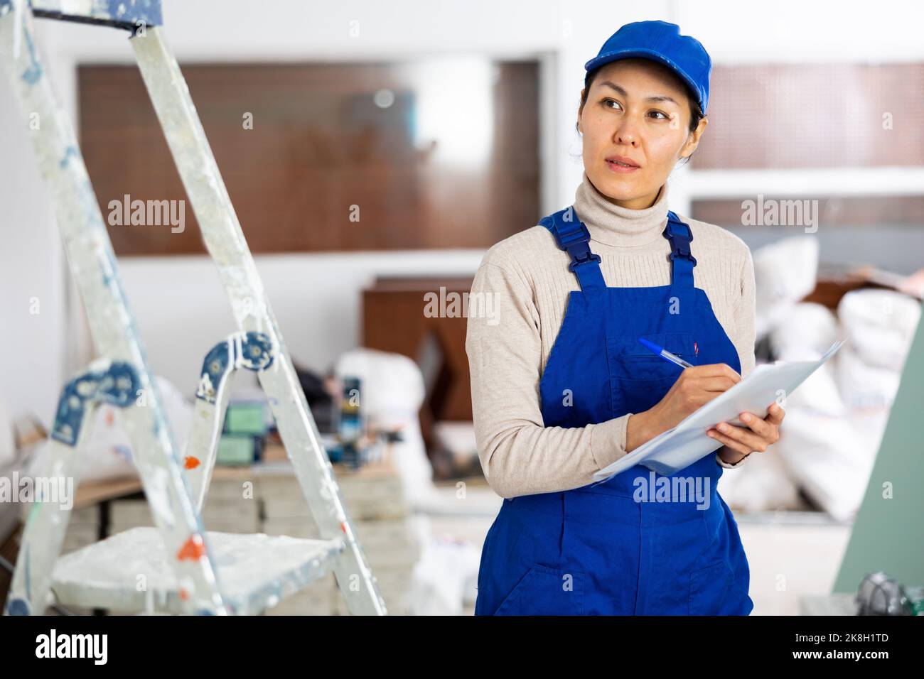 Female engineer matching check list during repair works Stock Photo - Alamy