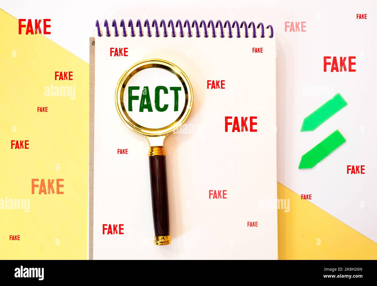 A magnifying glass looking to the words fact fake made with letter game ...