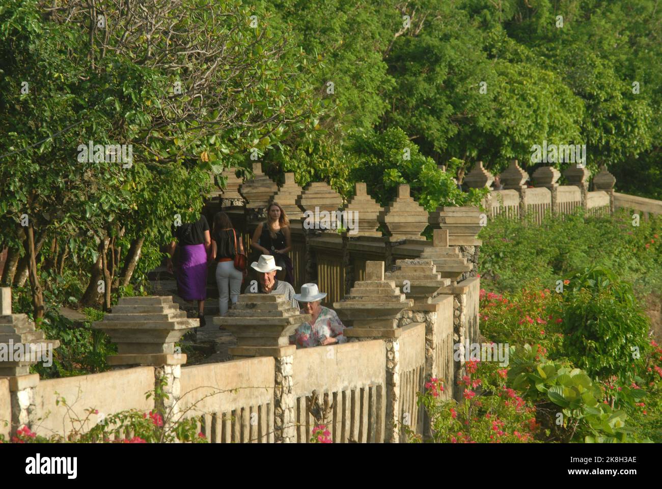 Tourists walking along cliff top walk, Uluwatu temple (Pura Luhur ...