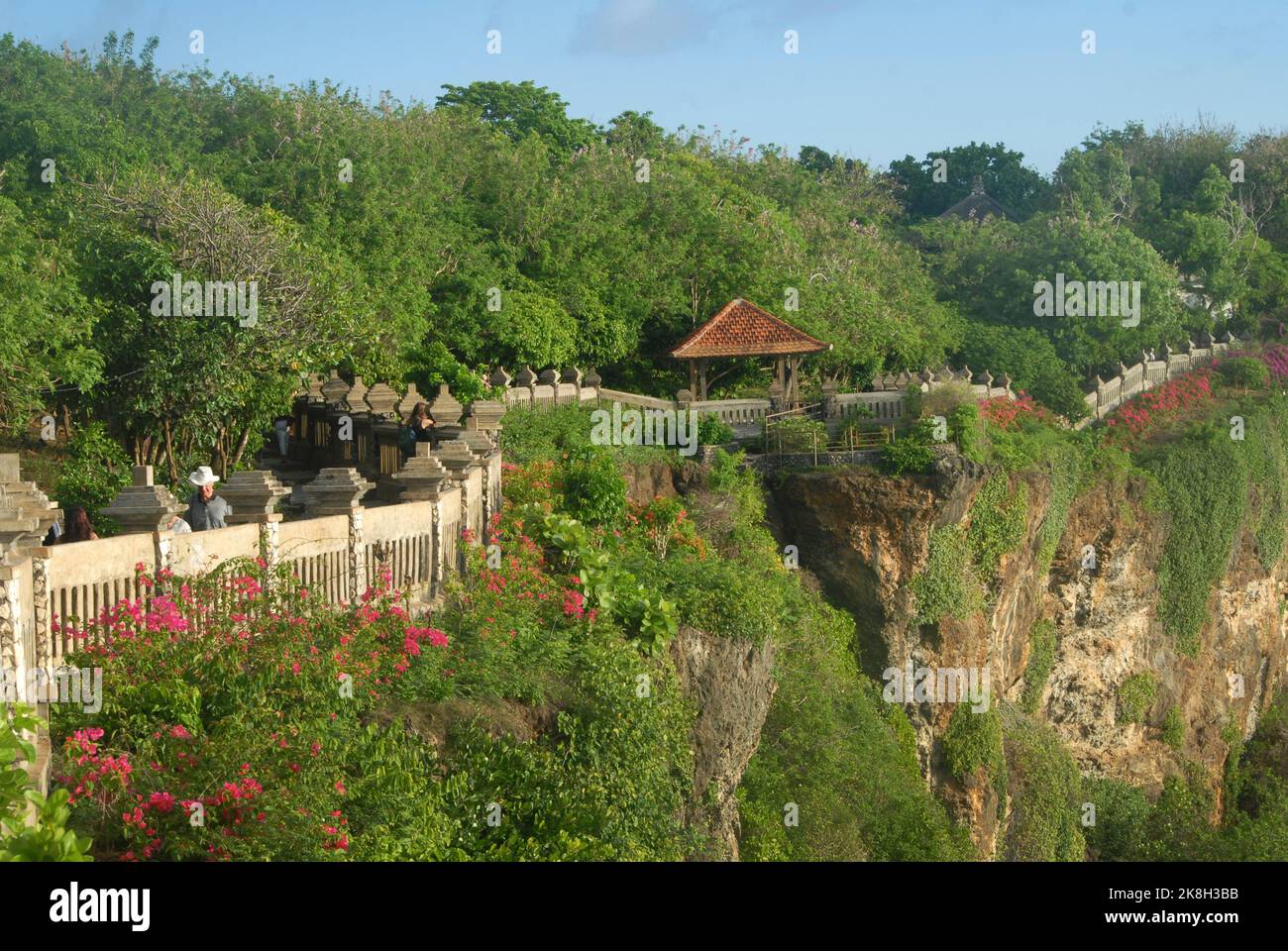 Tourists walking along cliff top walk, Uluwatu temple (Pura Luhur ...