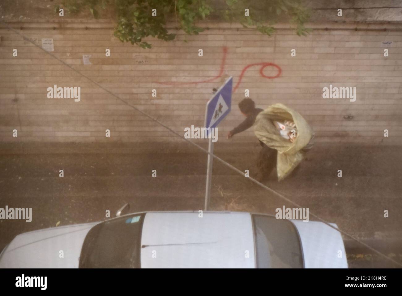 Tehran, Iran. 23rd Oct, 2022. A homeless man walks past a street in the ...