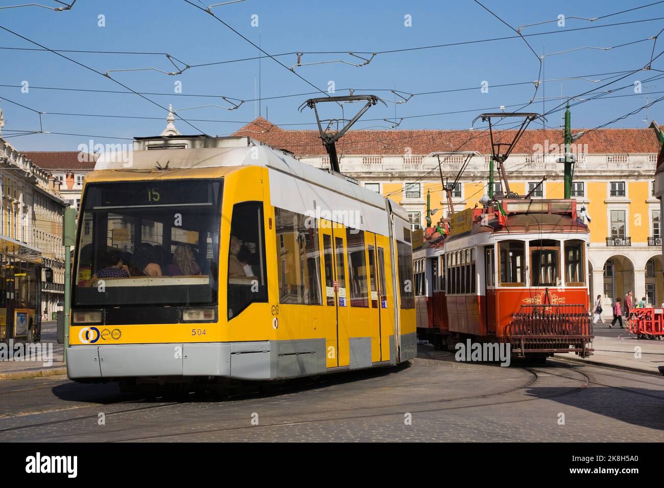 Modern and old electric trolley cars on a city street in Lisbon ...