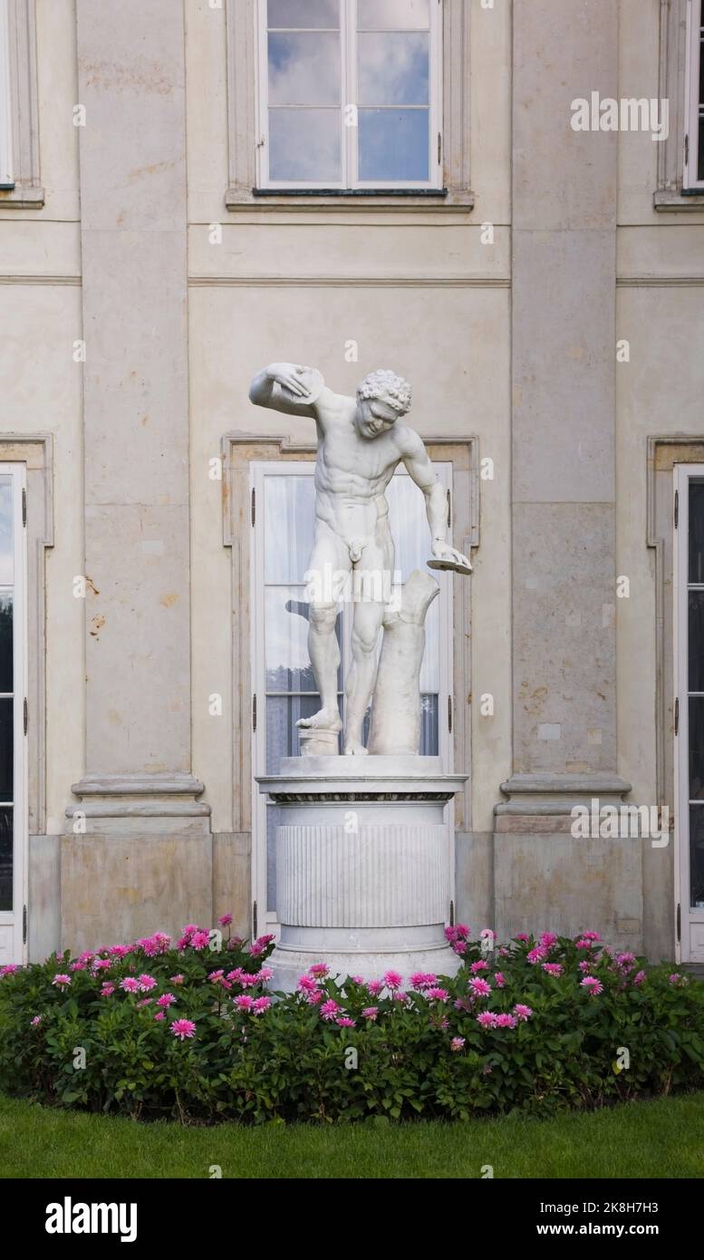 Marble statue surrounded by border of pink flowers in front of the ...