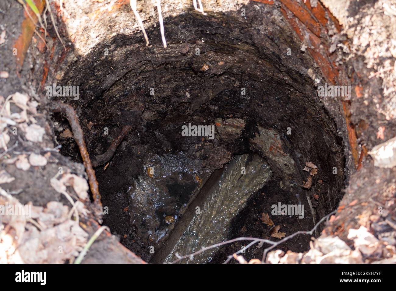 Flowing water at the bottom of a storm sewer well, an old brick ...