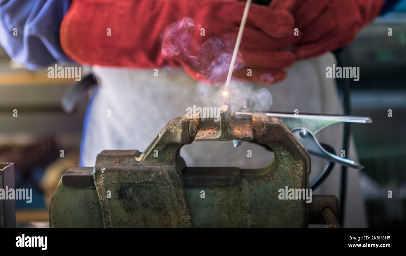 A man welder with safety helmet working with arc welding machine in the ...
