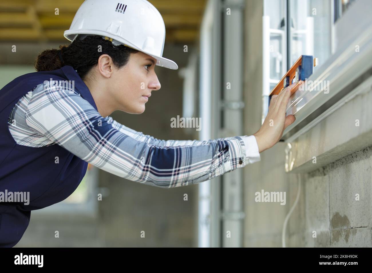 serious young woman checking the straightness of a window Stock Photo ...