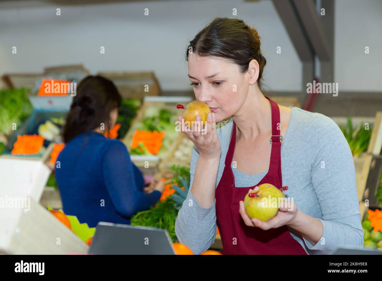 portrait of seller smelling fruits Stock Photo - Alamy