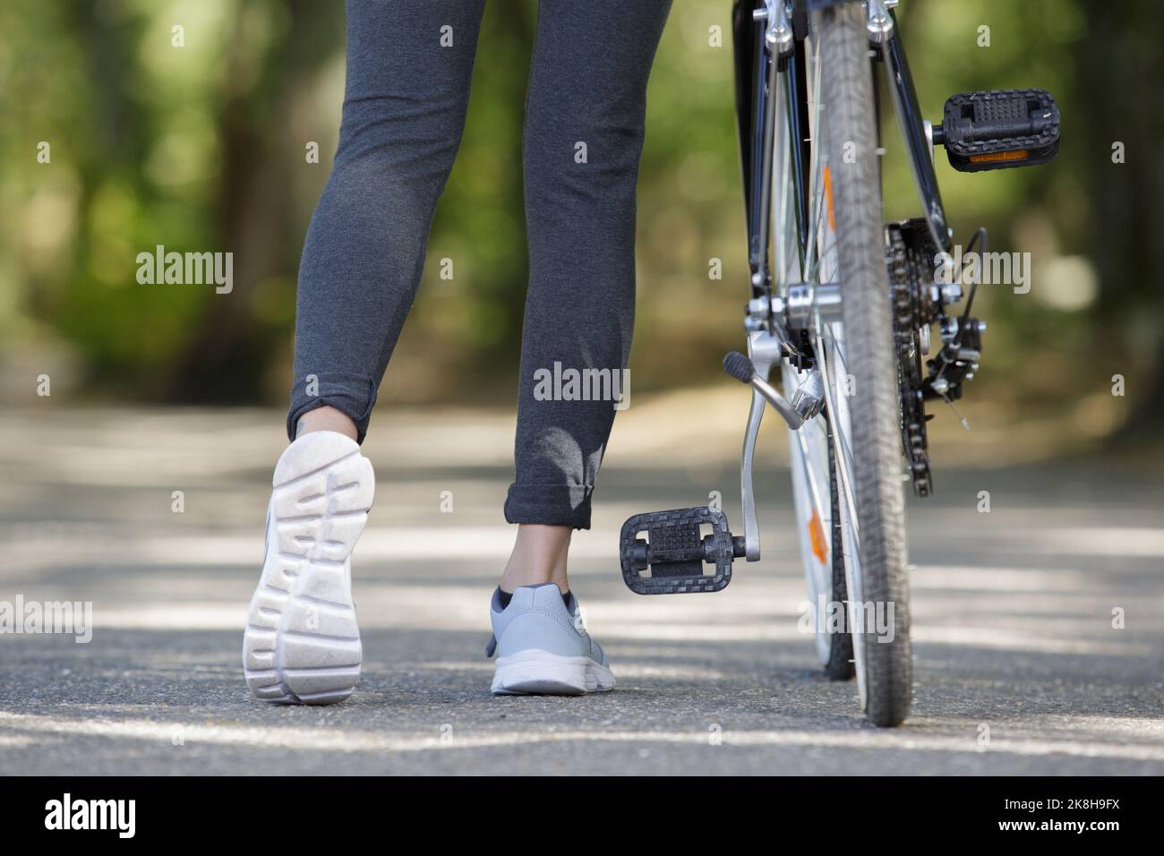 Woman wheeling a bicycle hi-res stock photography and images - Alamy