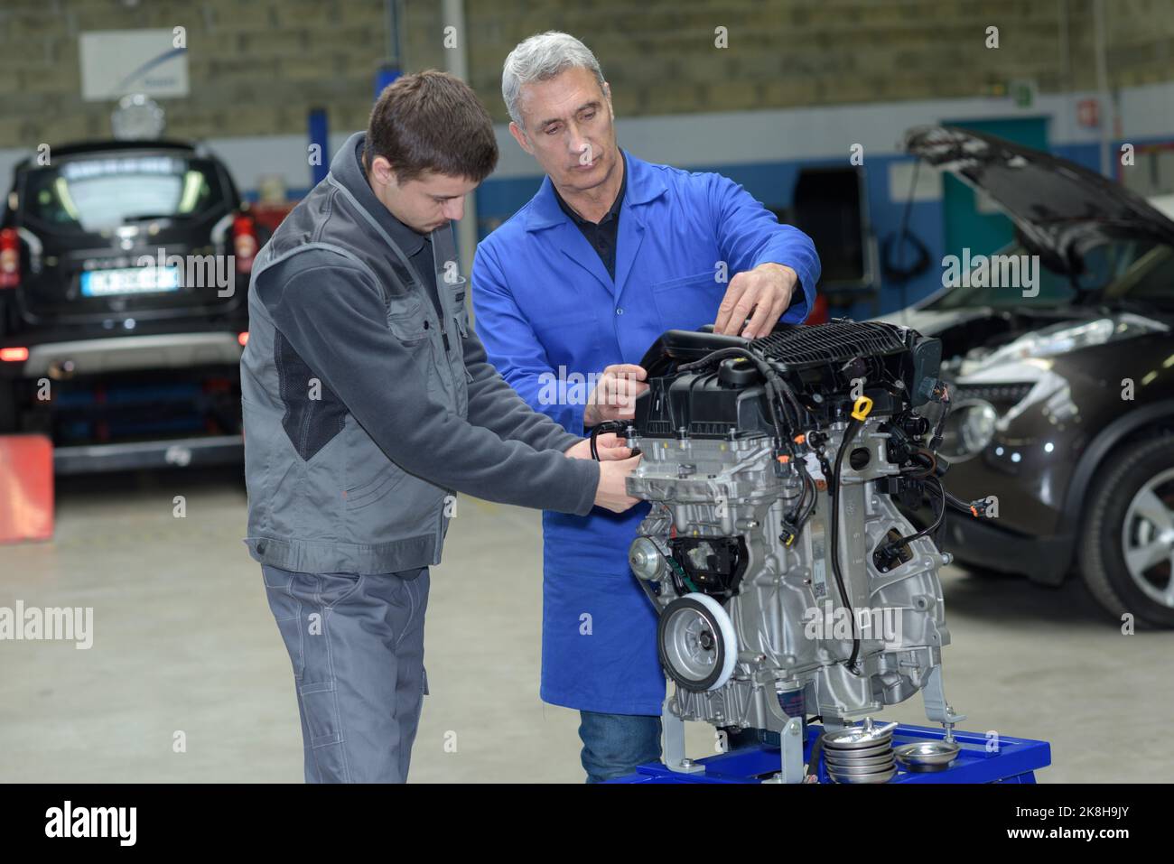 auto mechanic shows trainee maintenance of car engine Stock Photo - Alamy