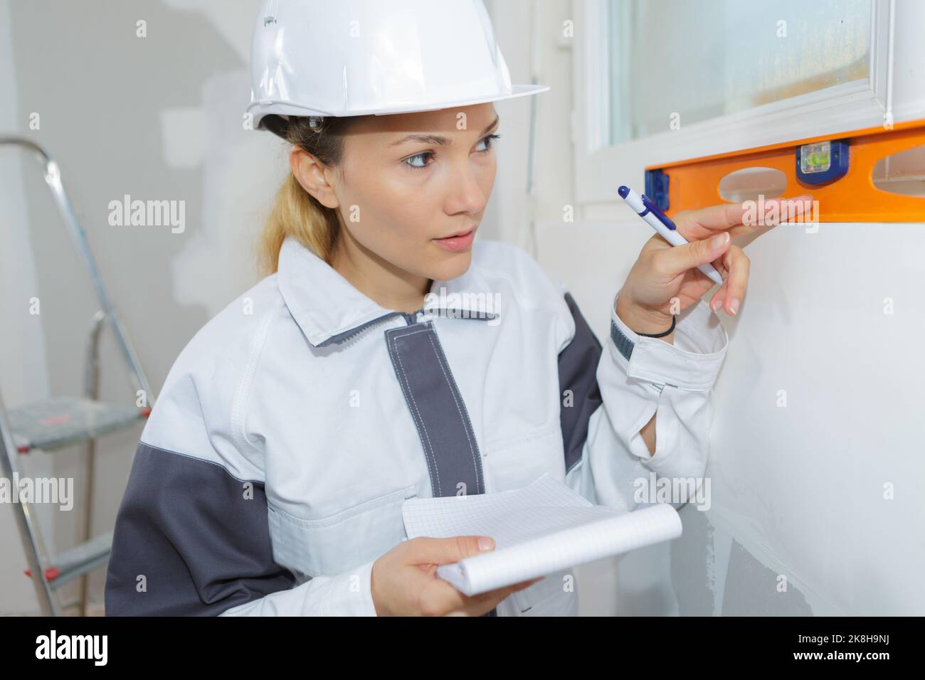 female construction worker installing window in house Stock Photo - Alamy