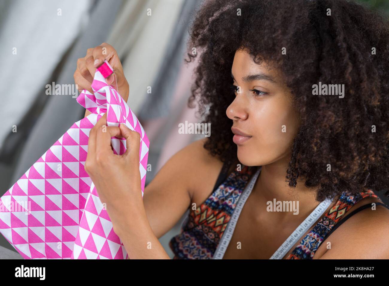 pretty young fashion designer with cloth Stock Photo - Alamy