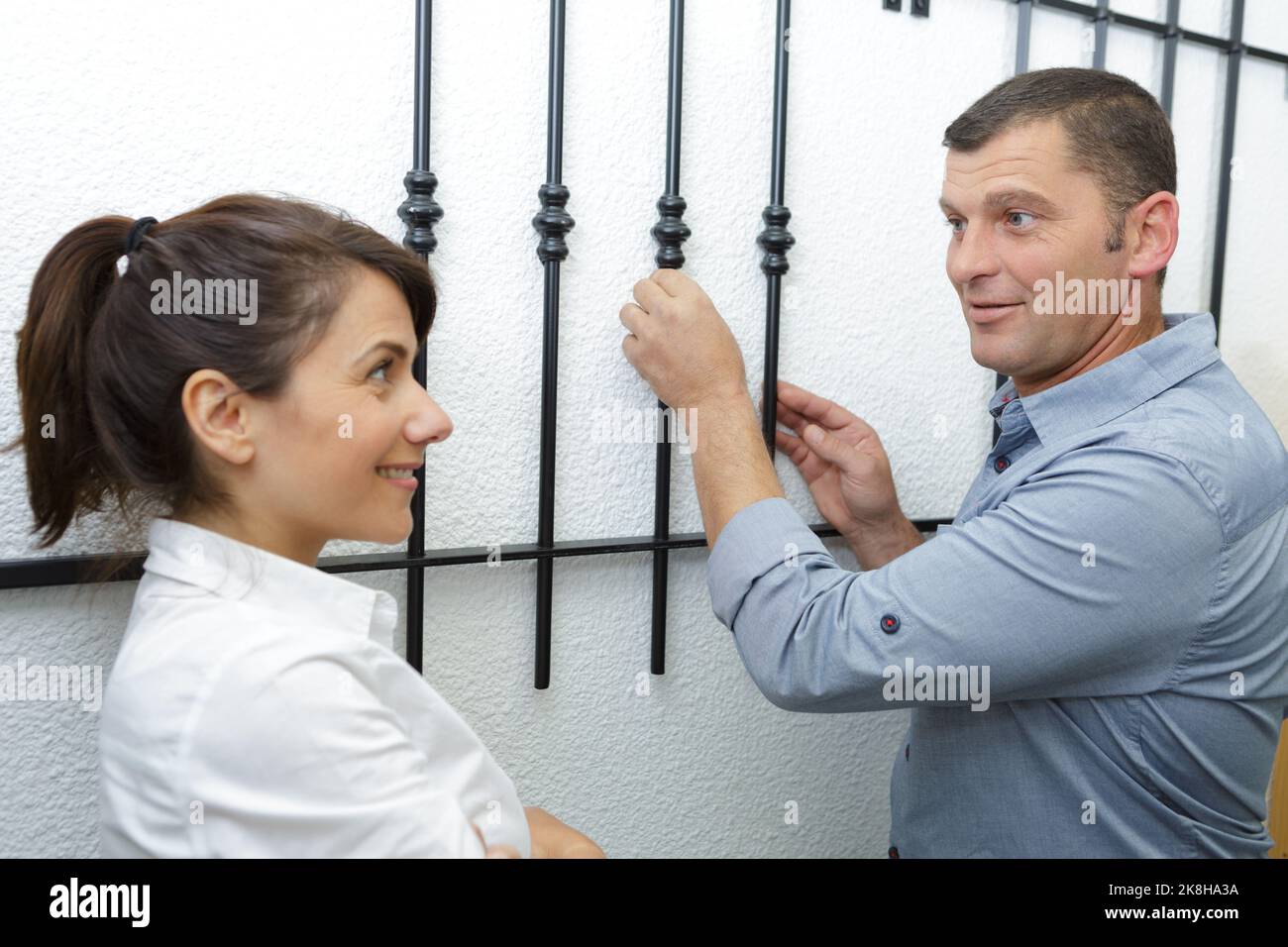 sales clerk showing metal window security bars to customer Stock Photo ...