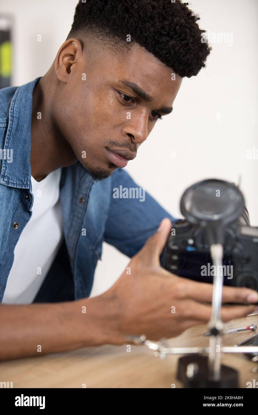 man trying to repair a camera Stock Photo - Alamy