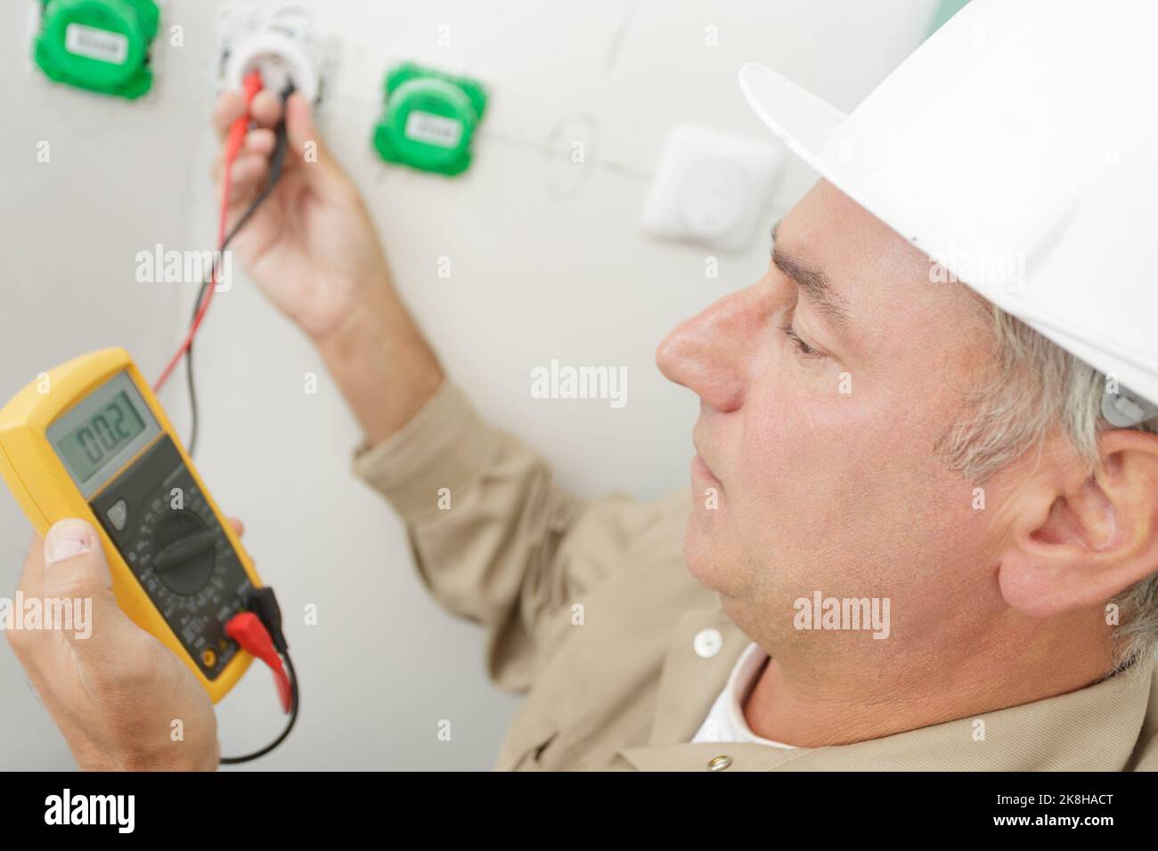 electrician measuring voltage of socket in new building Stock Photo - Alamy