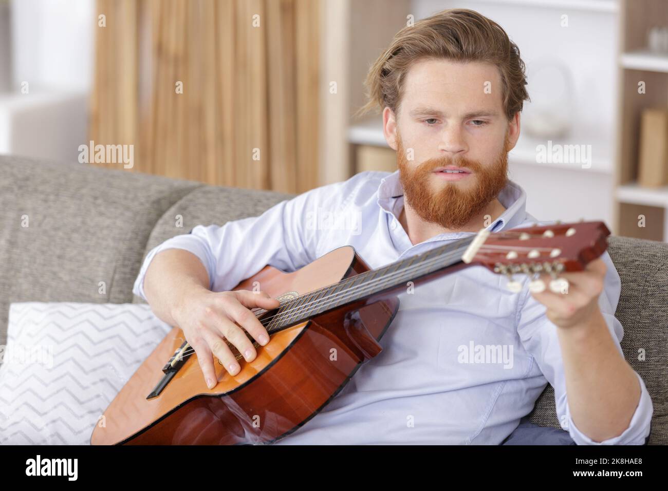 male musician tuning an acoustic guitar Stock Photo - Alamy