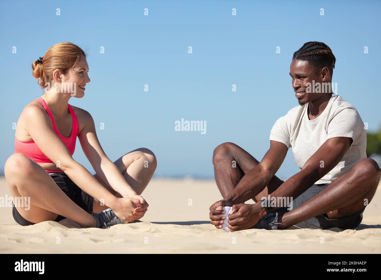 multi-racial couple exercise on the beach Stock Photo - Alamy