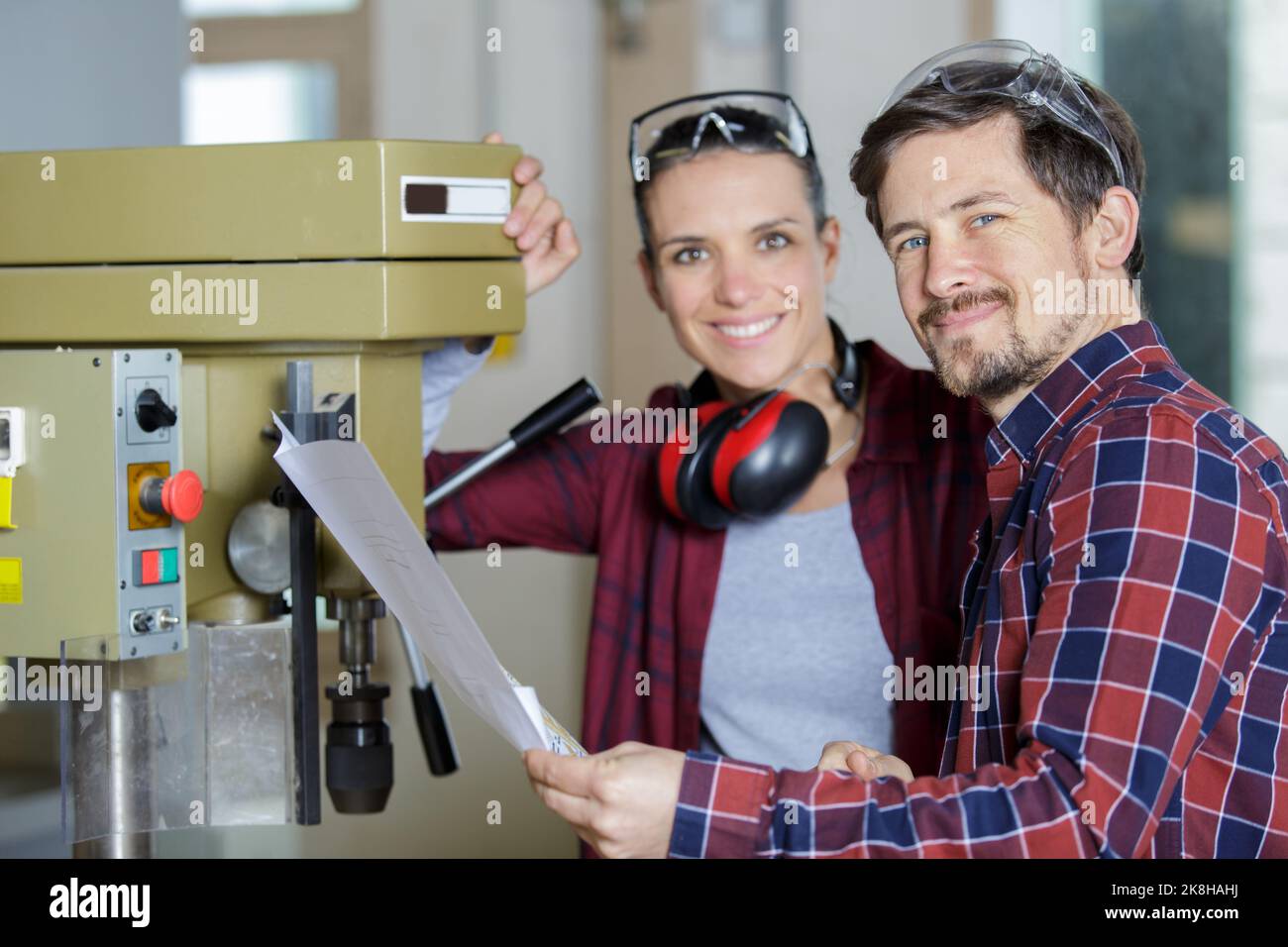 male and female workers by machinery in factory Stock Photo - Alamy