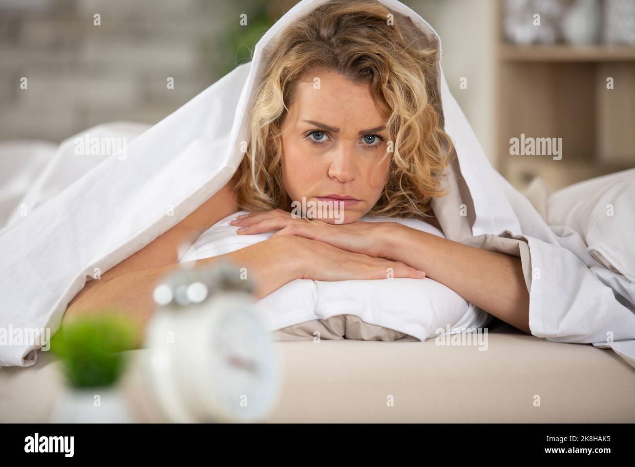 sleepless woman lying down on bed tired Stock Photo - Alamy