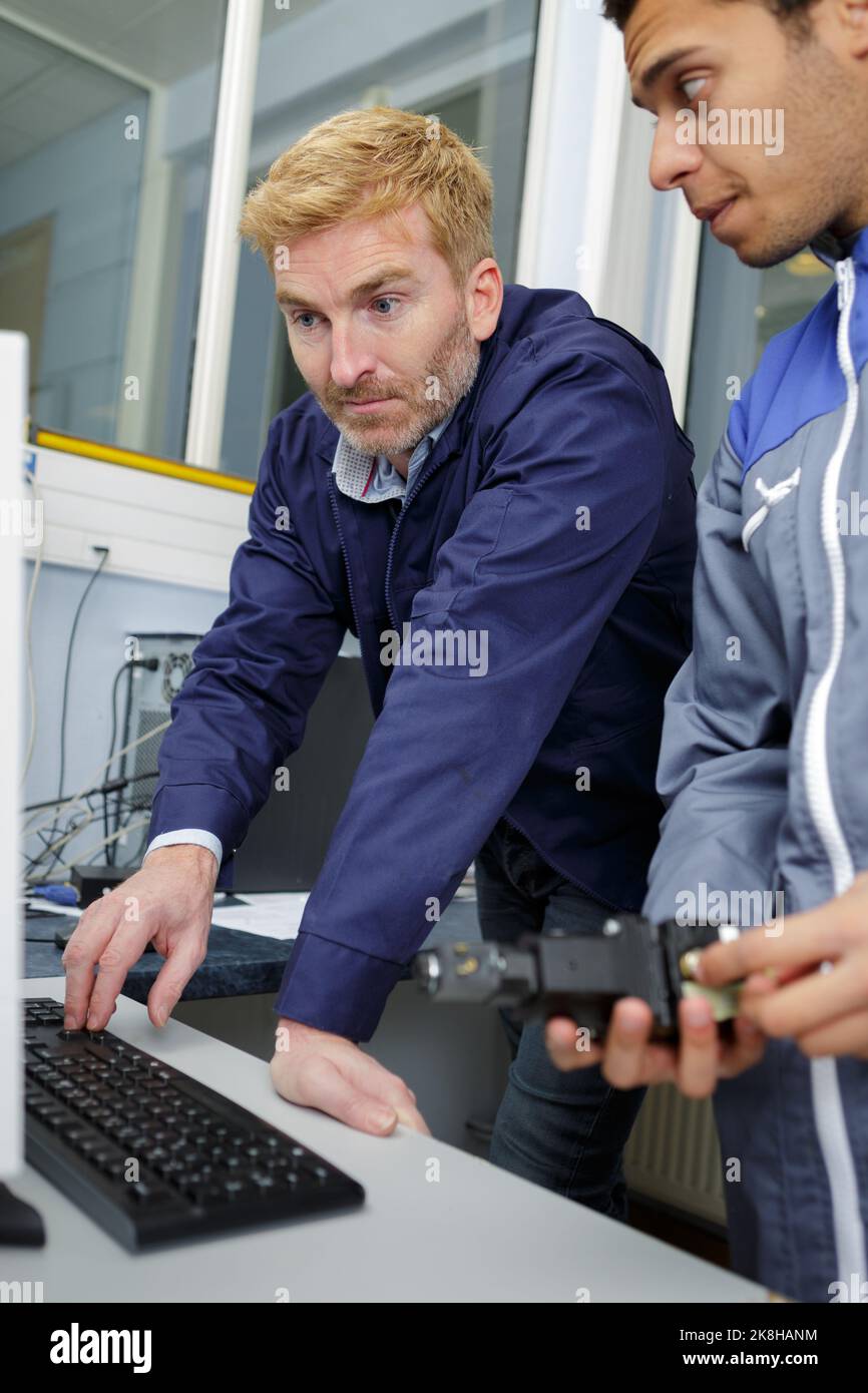 two male mechanical engineers standing in office Stock Photo - Alamy