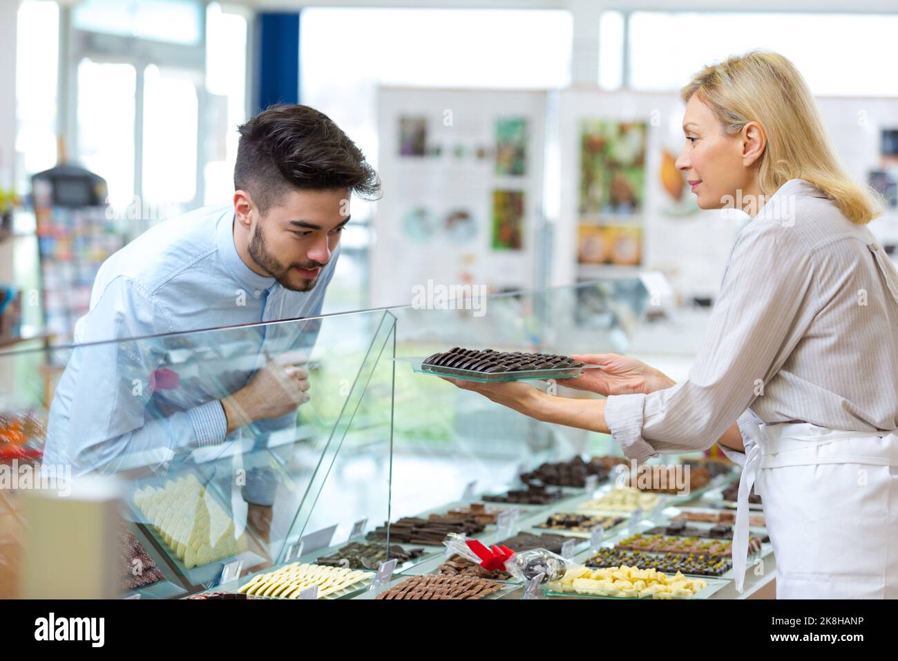 customer choosing delicious chocolate in shelf Stock Photo - Alamy