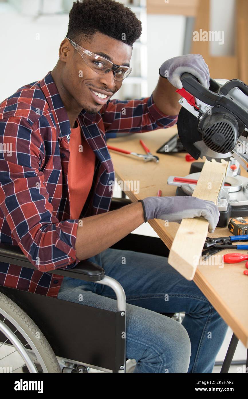 happy disabled man working with circular saw Stock Photo - Alamy