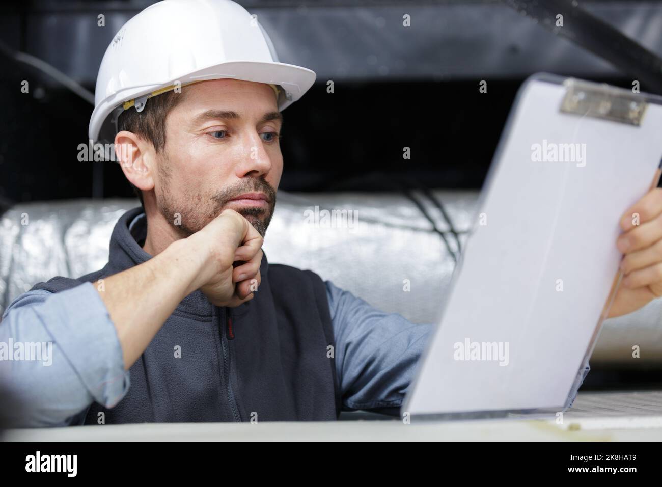 modern builder with clipboard in roof Stock Photo - Alamy