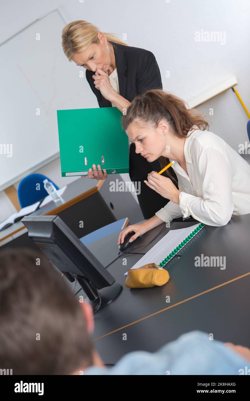 female tutor using computer in it class Stock Photo - Alamy