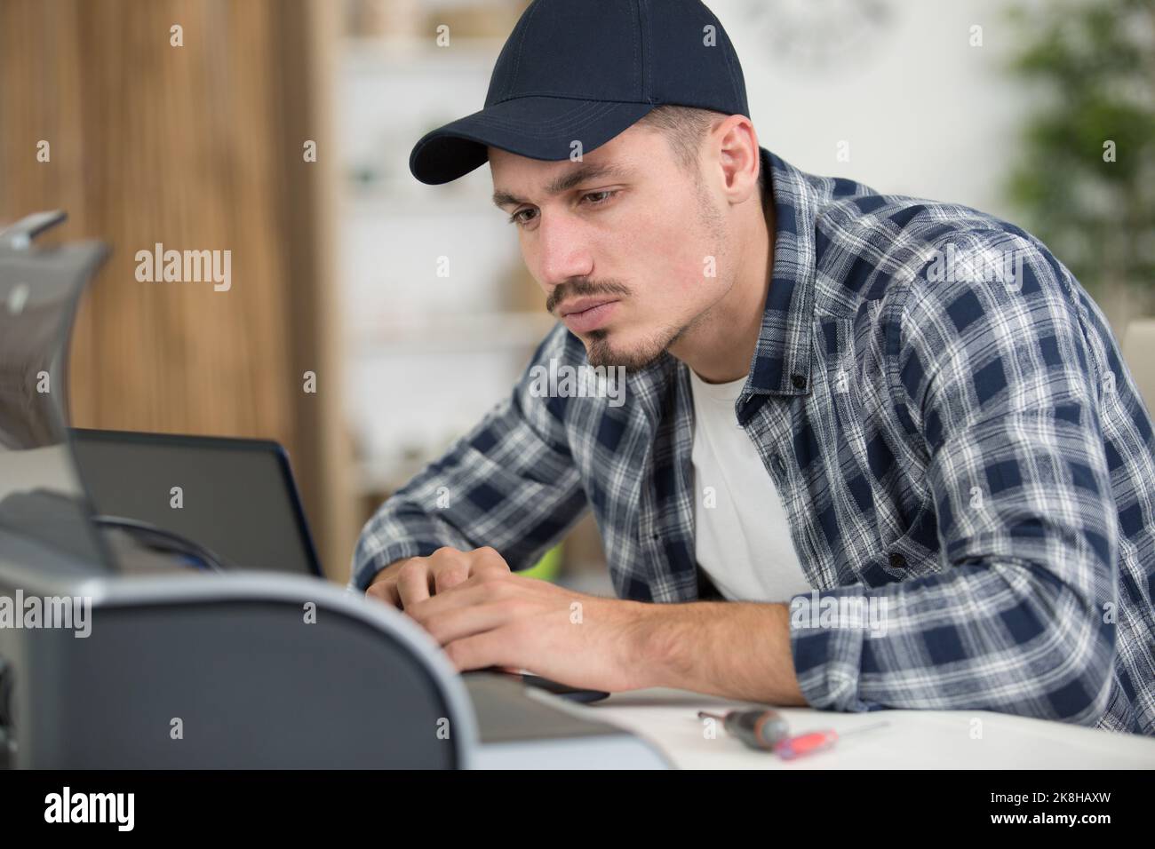 man leaning over open photocopier during maintenance Stock Photo - Alamy