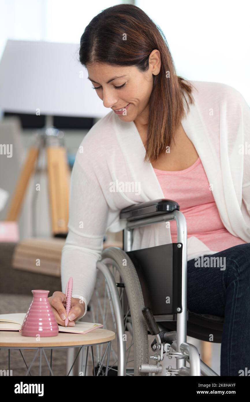 disabled woman in wheelchair writing taking notes Stock Photo - Alamy
