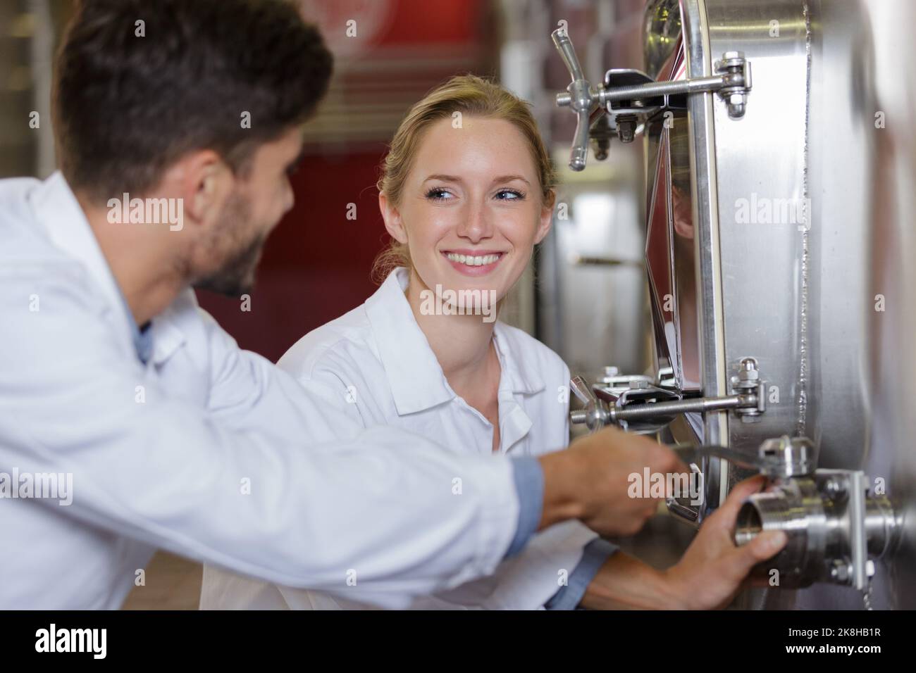 two young distillery workers smiling Stock Photo - Alamy