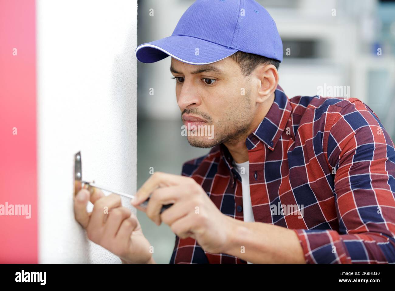 man installer attaches metal hooks for shelving Stock Photo - Alamy