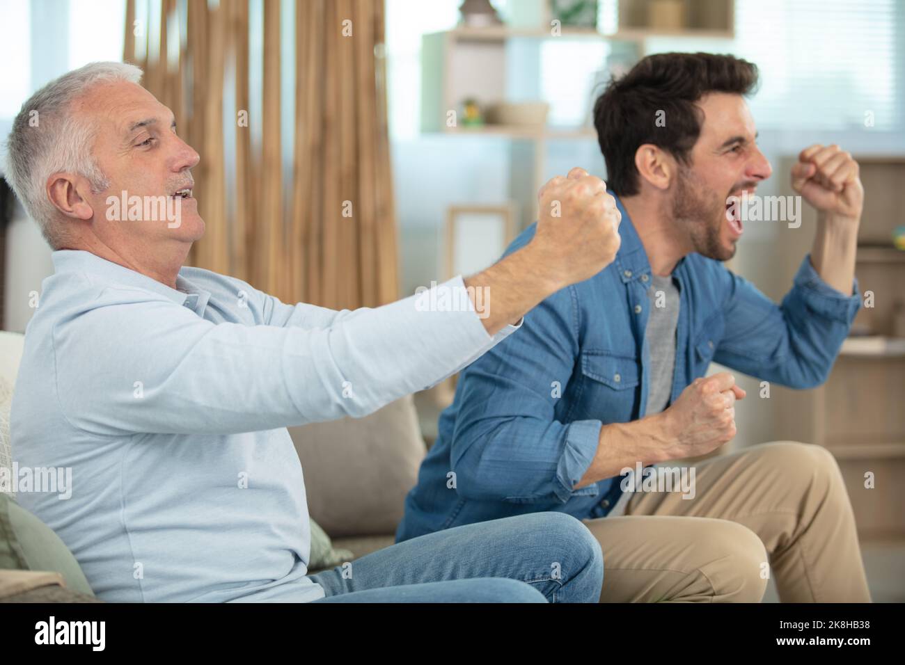 smiling senior father sit on couch watching tv Stock Photo - Alamy