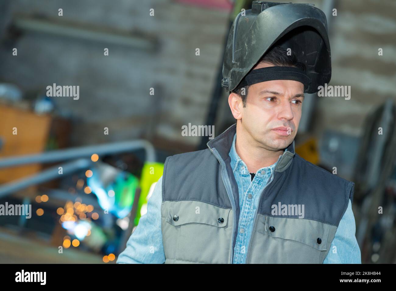 positive welder looking away in a factory Stock Photo - Alamy